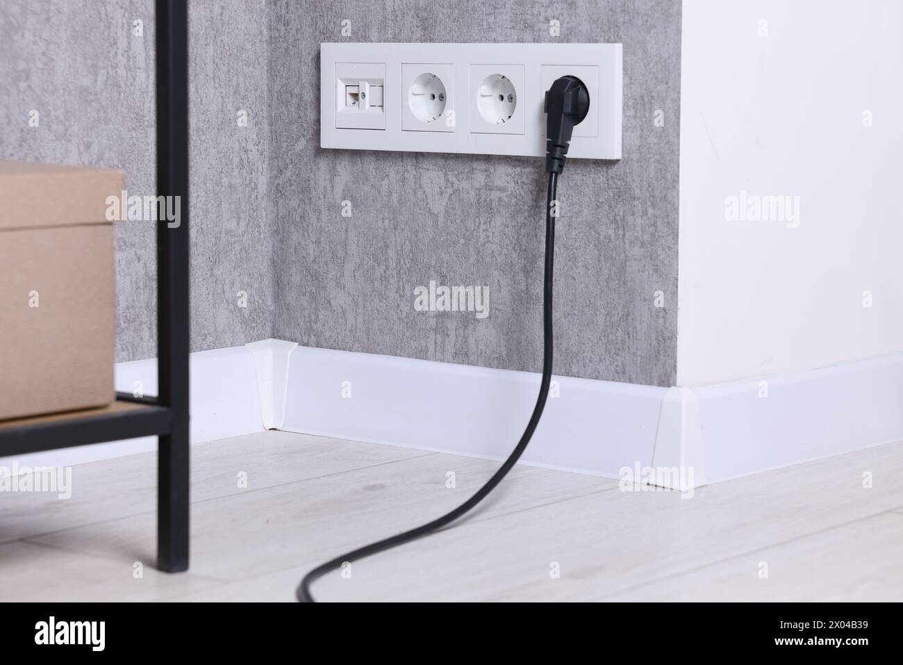 Power sockets and electric plug on grey wall Stock Photo - Alamy