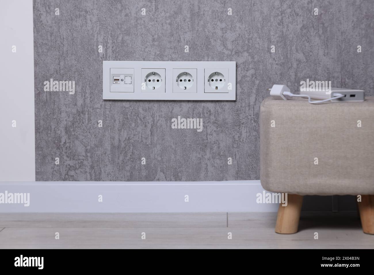 Electric power sockets on grey wall indoors Stock Photo - Alamy