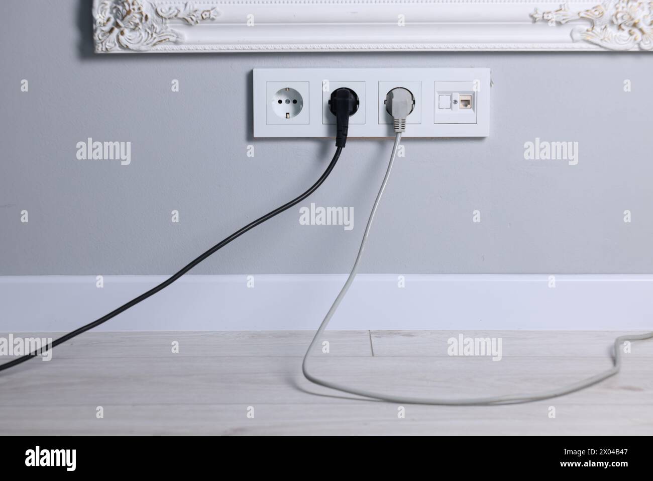 Power sockets and electric plugs on grey wall Stock Photo - Alamy