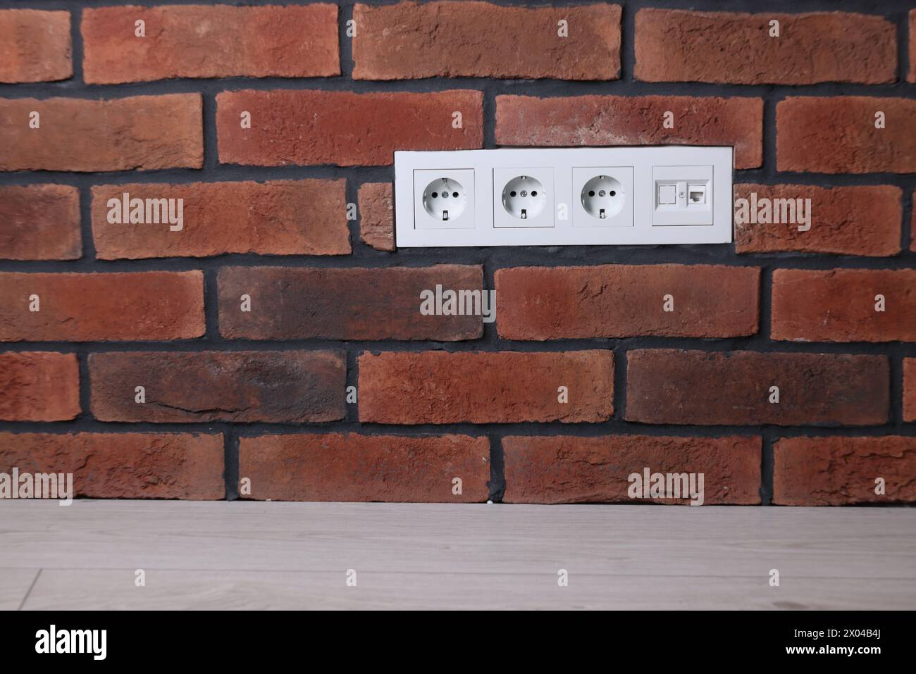 Electric power sockets on brick wall indoors Stock Photo - Alamy