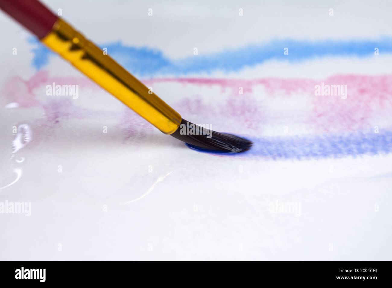 Wet on wet technique. Artist applying wet watercolor paint to wet paper ...