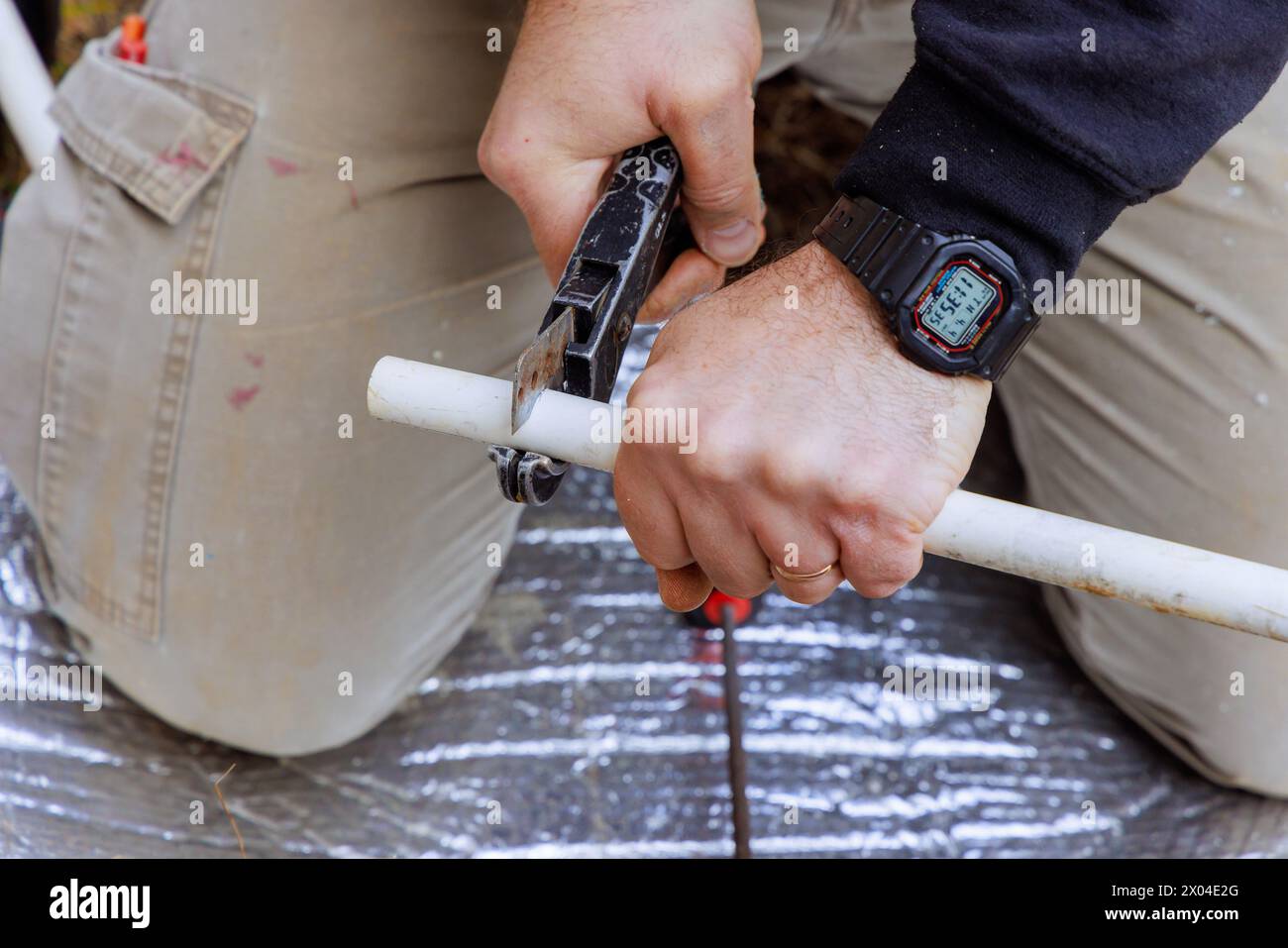 Technician plumber cuts a plastic PVC pipe by special scissors Stock ...