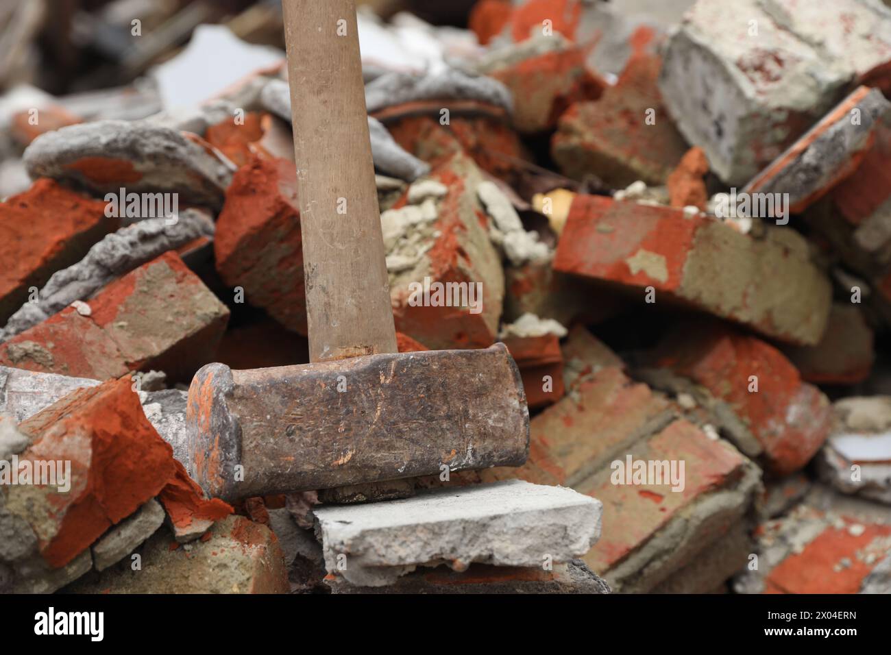 Sledgehammer on pile of broken bricks, closeup Stock Photo - Alamy