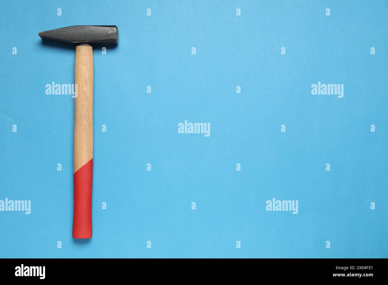 New hammer with wooden handle on light blue background, top view. Space ...