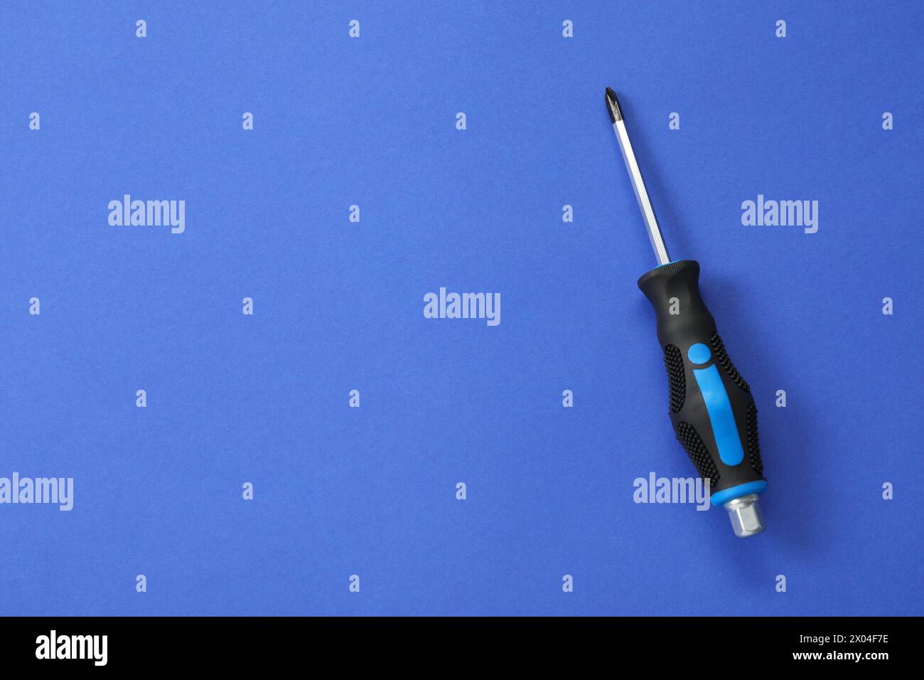 Screwdriver with black handle on blue background, top view. Space for ...