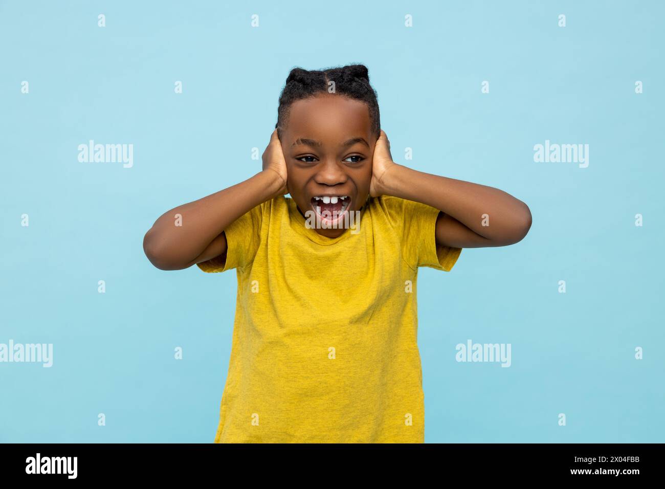 Excited dark- skinned little boy suffering from loud sound Stock Photo ...