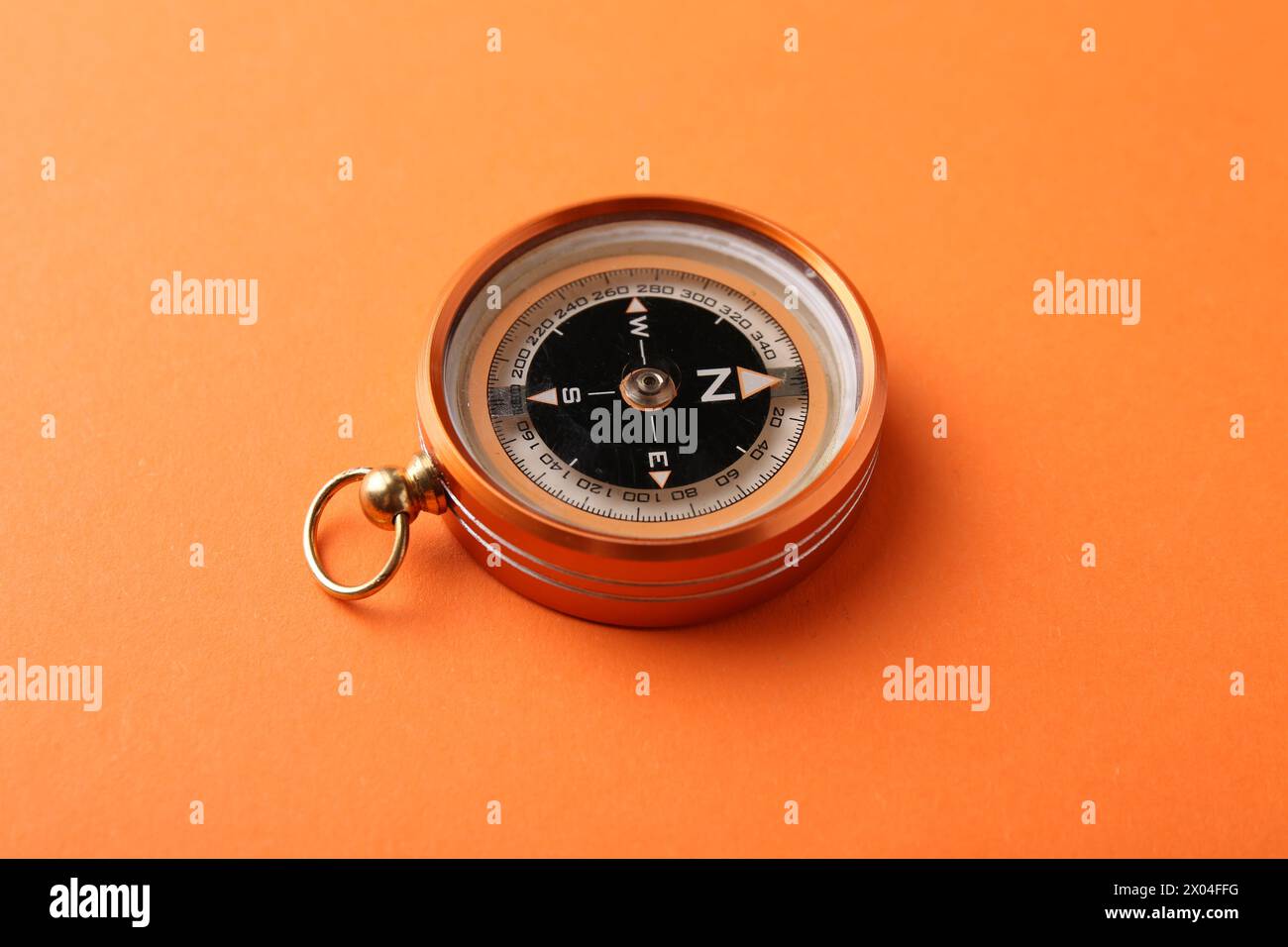 One compass on orange background. Tourist equipment Stock Photo - Alamy