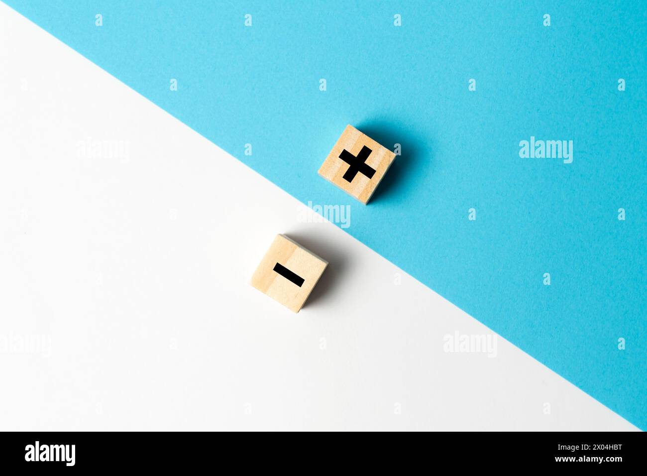Wood block with plus and minus sign on blue and white background, the ...