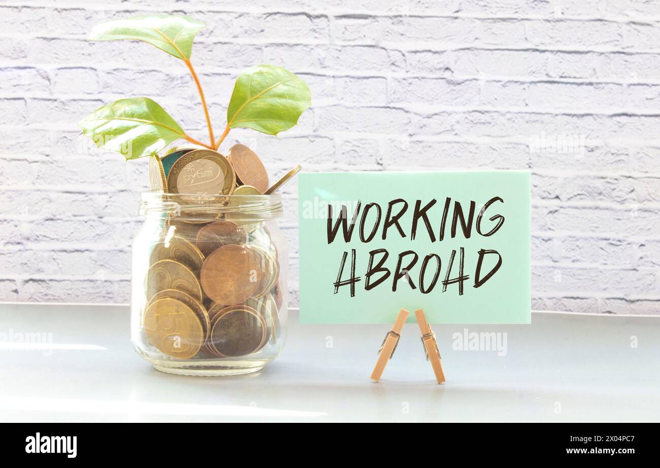Working Abroad text on the desk on yellow background Stock Photo - Alamy