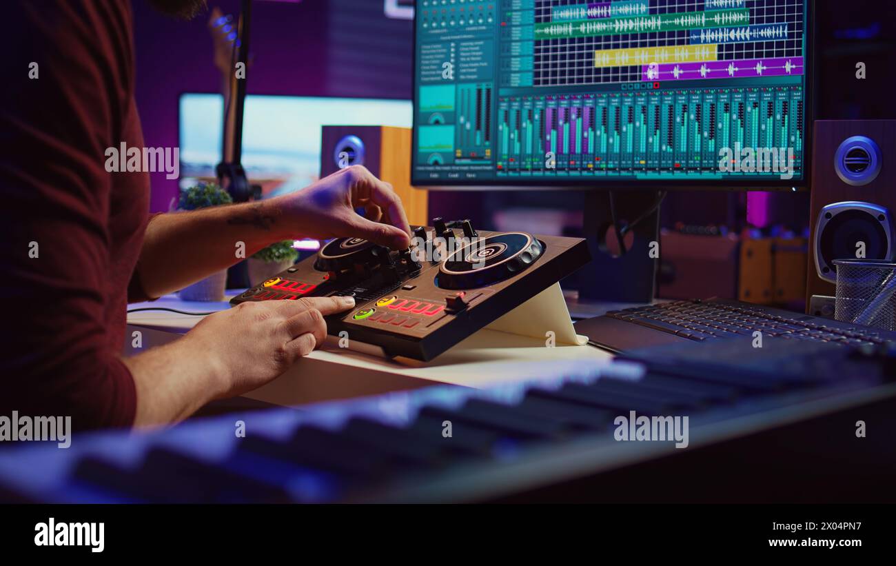 Artist editing sounds on mixing console in home studio, operating ...