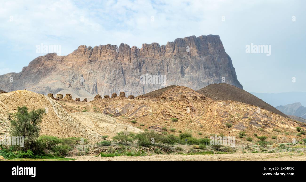 Group of ancient stone beehive tombs with Jebel Misht mountain in the ...