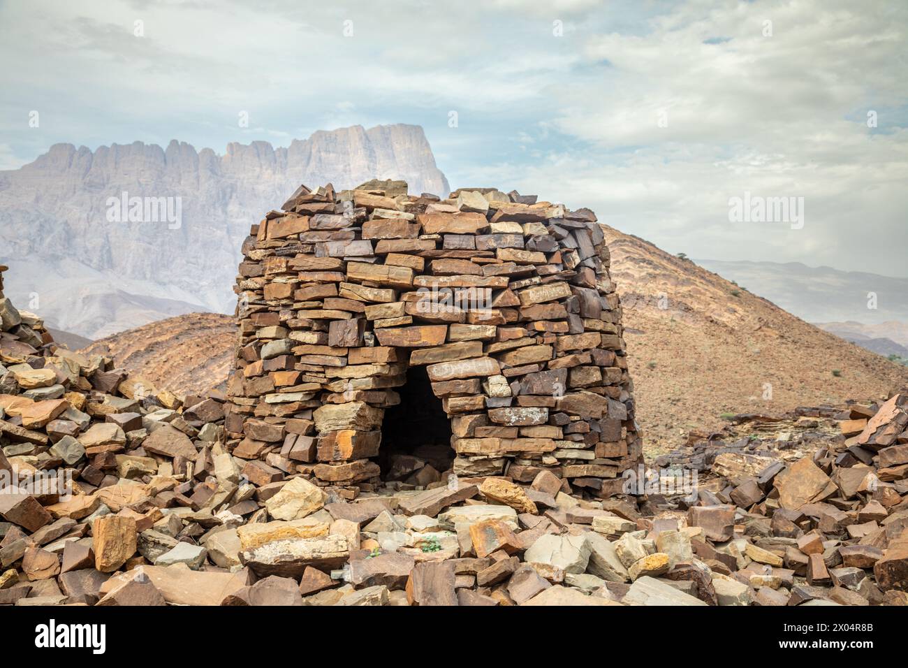 Ancient stone beehive tombs with Jebel Misht mountain in the background ...