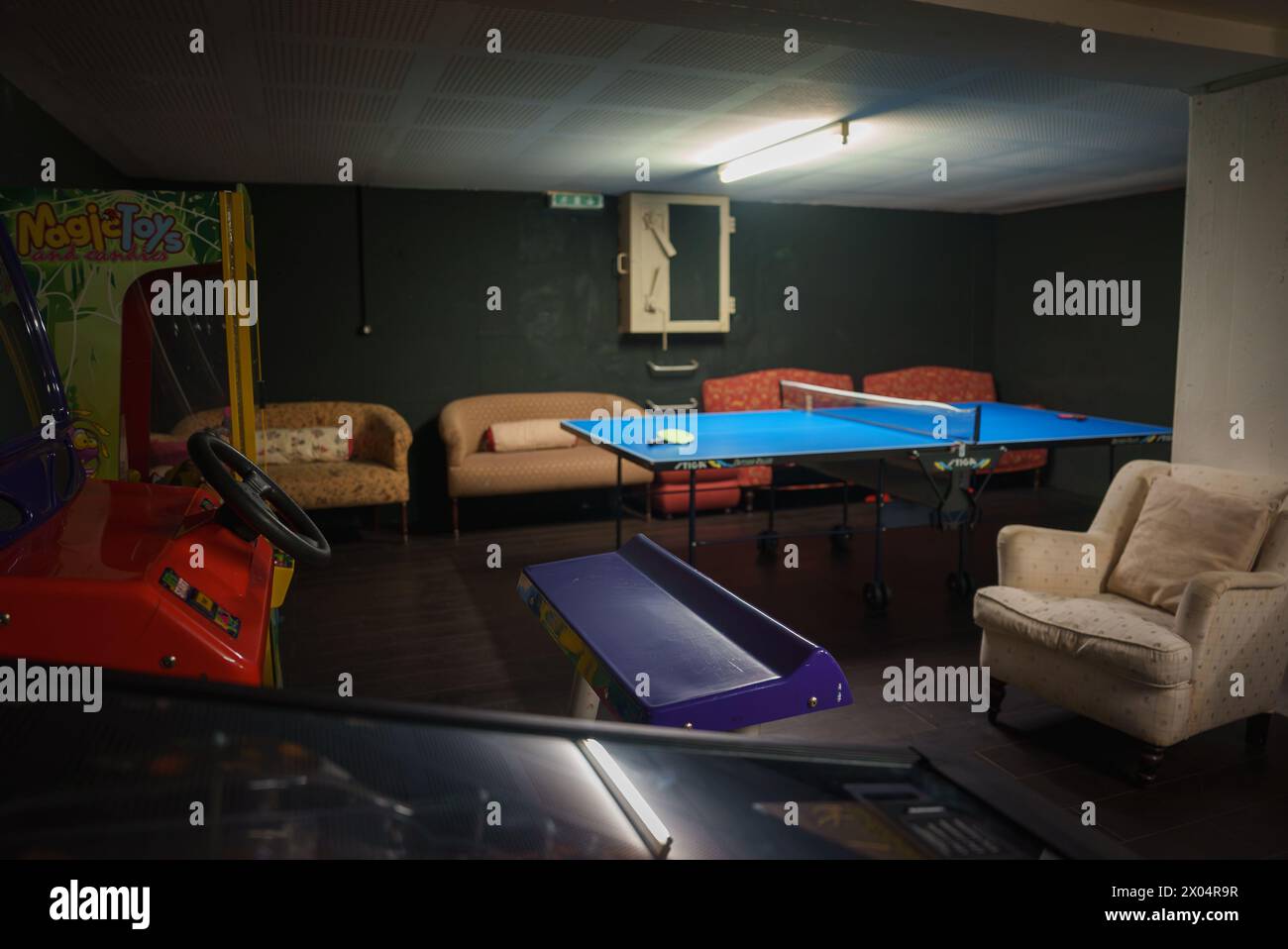 Entertainment room with arcade game, ping pong table, sofas, and ...
