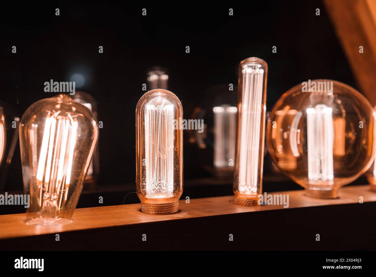 Vintage style illuminated light bulbs on wooden surface, warm amber ...