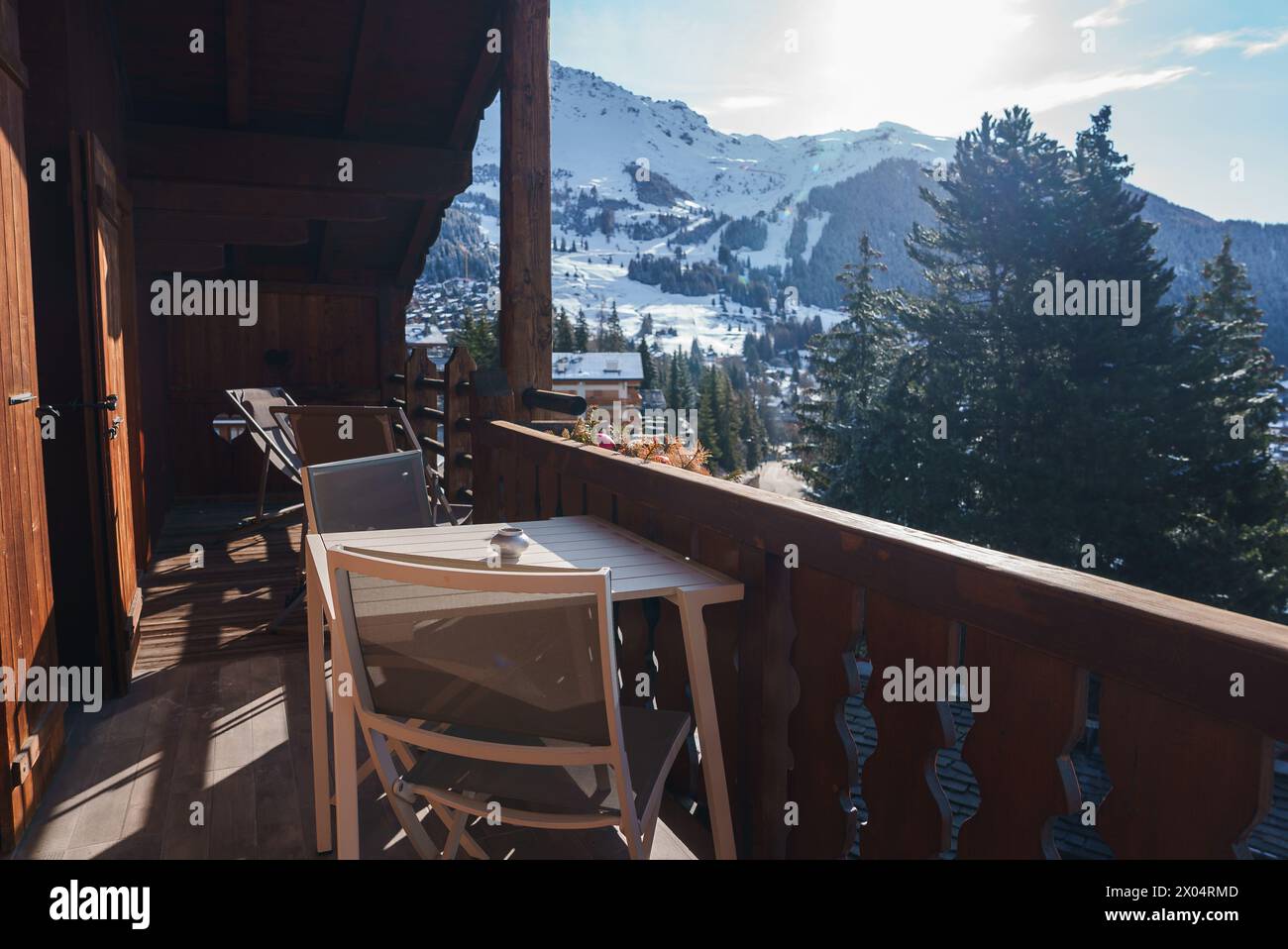 Wooden balcony overlooking snow covered mountains in alpine village ...