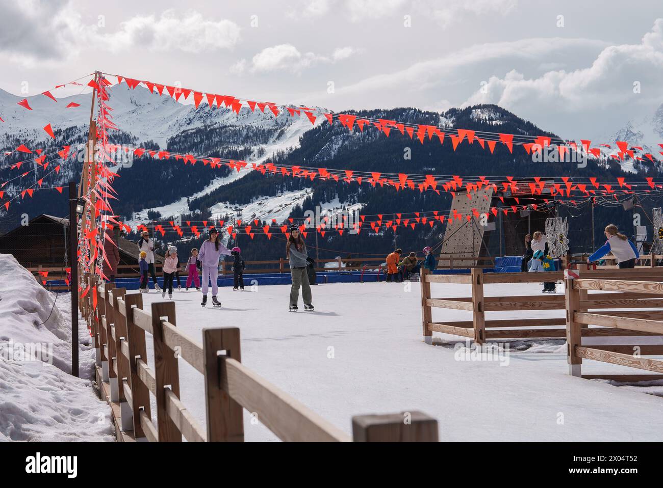 Outdoor ice skating rink with bright flags in mountainous setting Stock ...