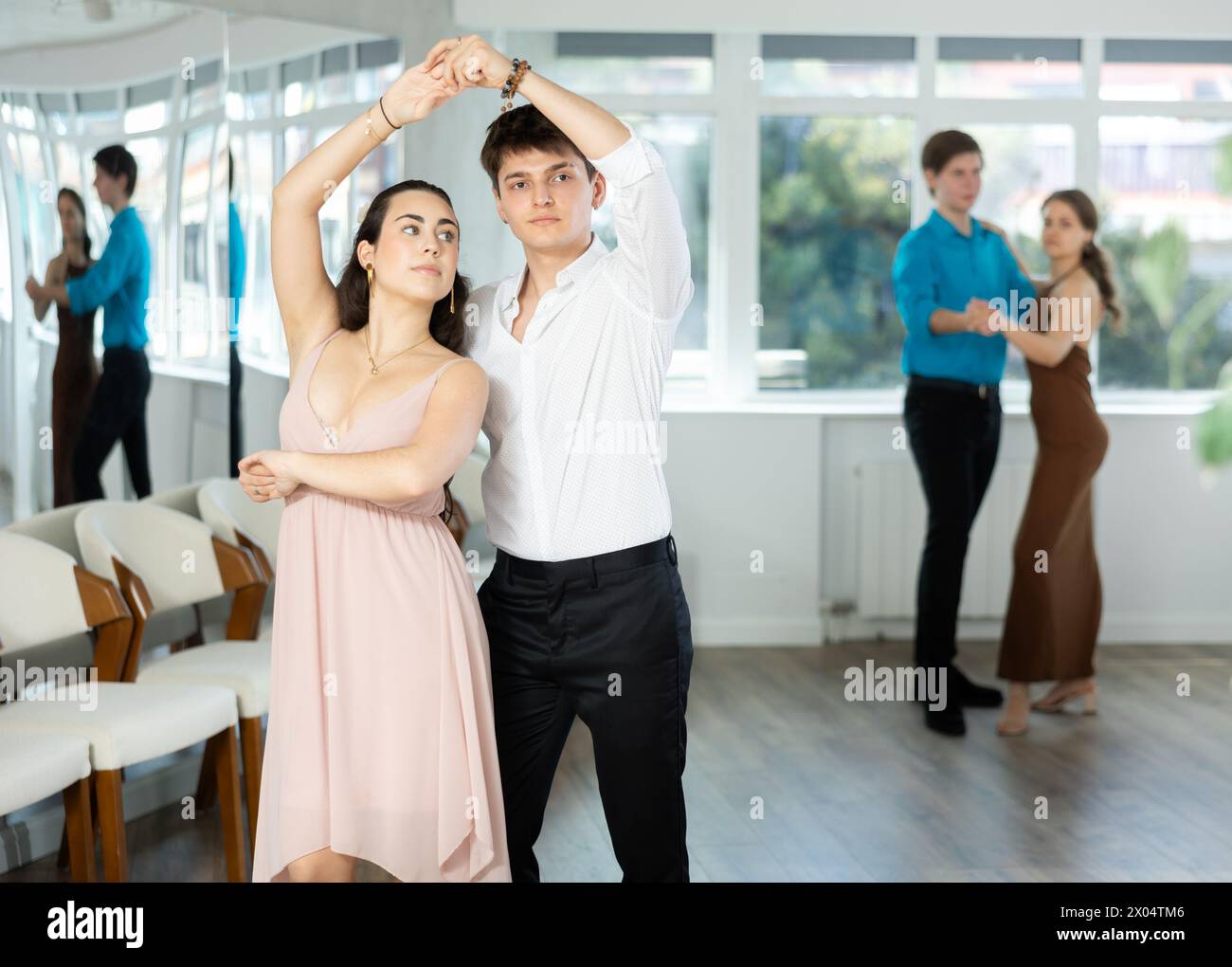 Couple in evening dresses enjoys pair dance tango, interacting with ...