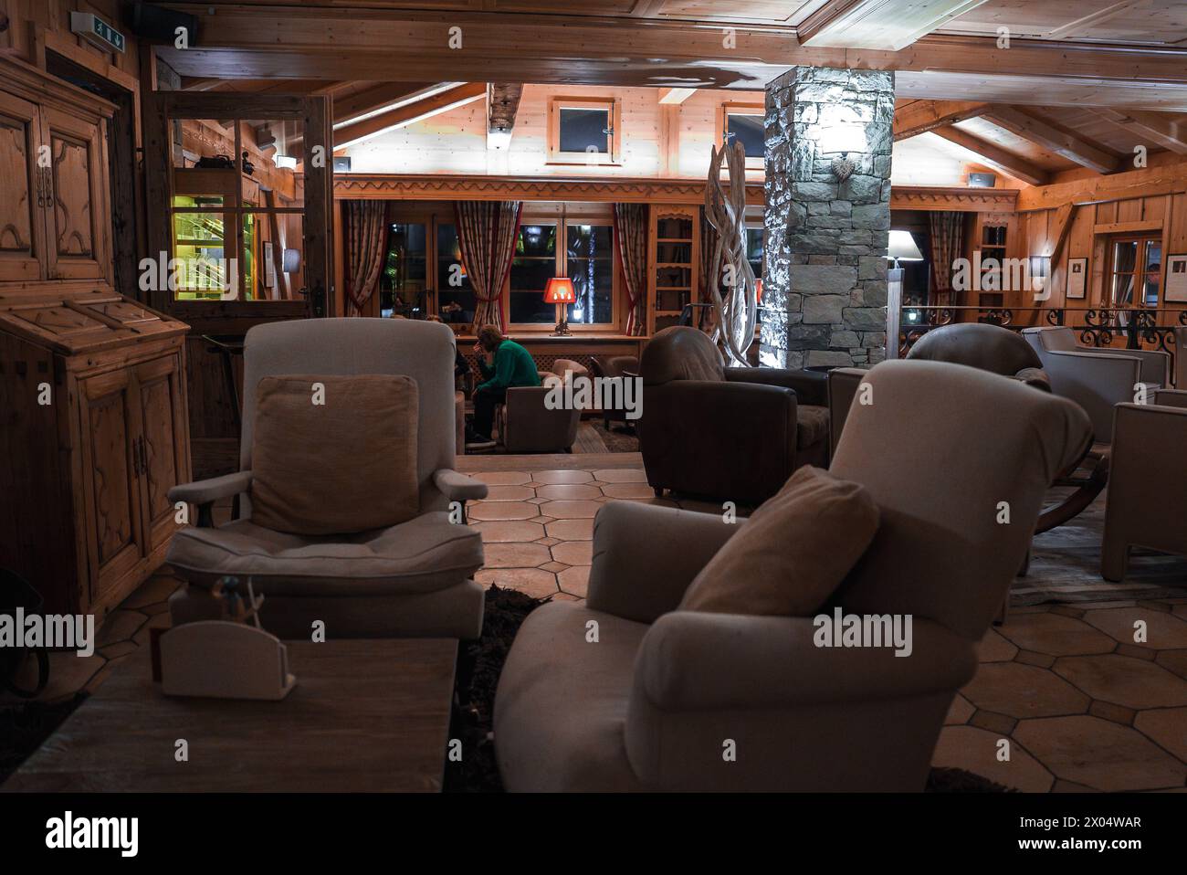 Cozy rustic lounge interior with plush armchairs and stone column in ...