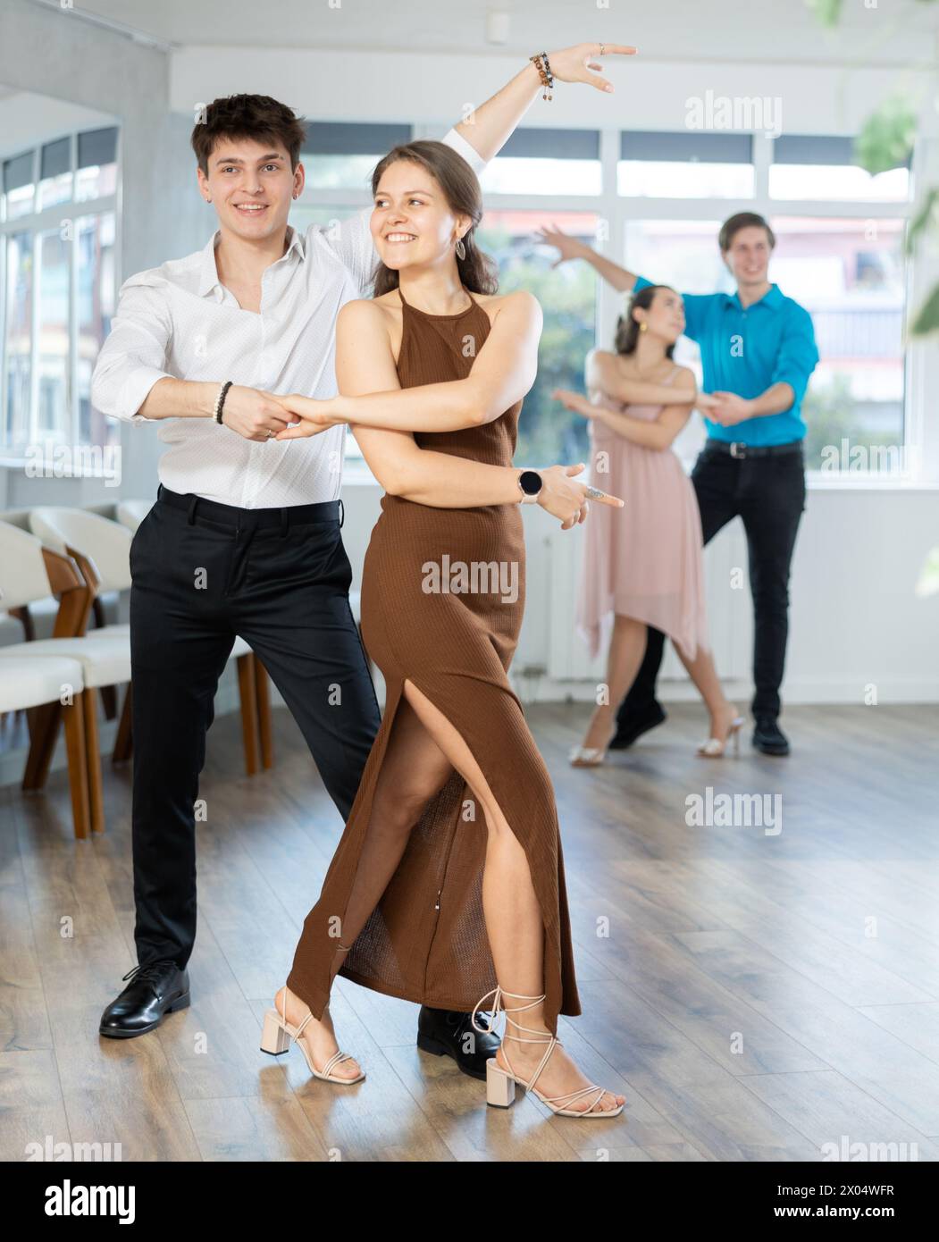 Couple in evening dresses enjoys pair dance tango, interacting with ...