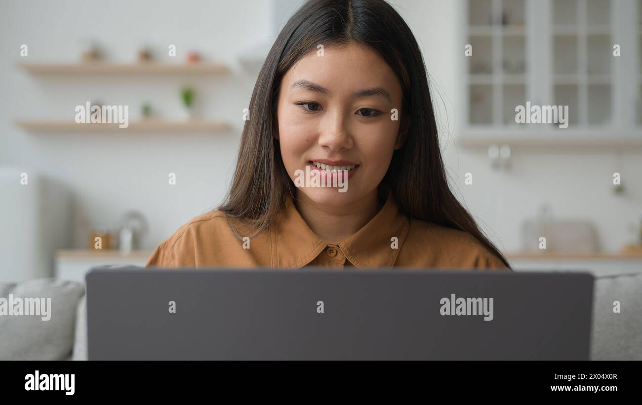 Asian woman typing laptop in kitchen korean vietnamese businesswoman ...