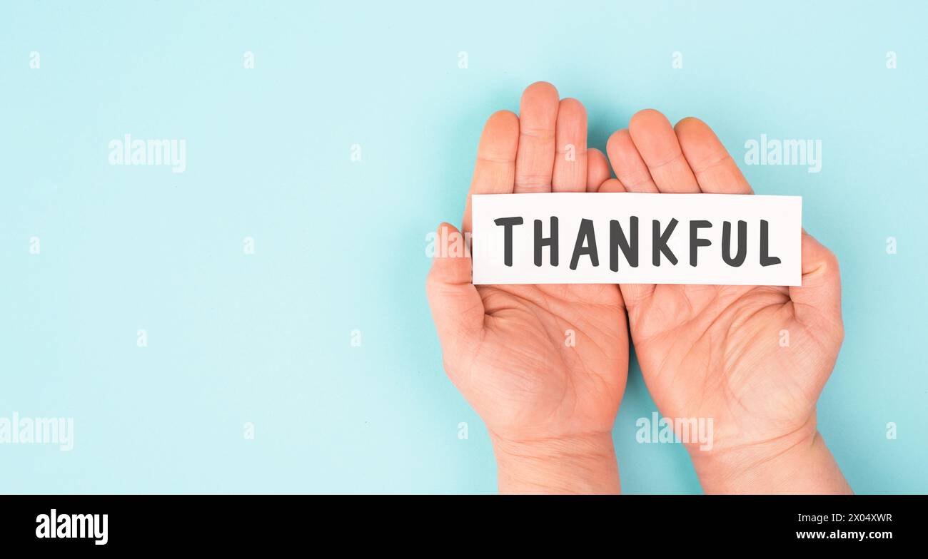 Thankful sign in hand, thank you, support, help and charity concept ...