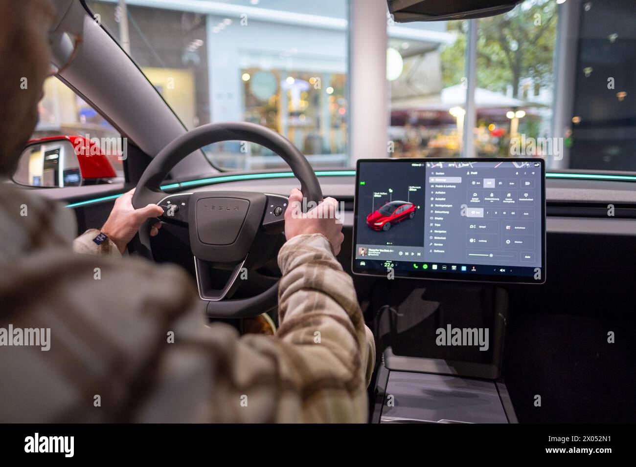 Tesla test drive, Young man, potential buyer, sits in car interior ...