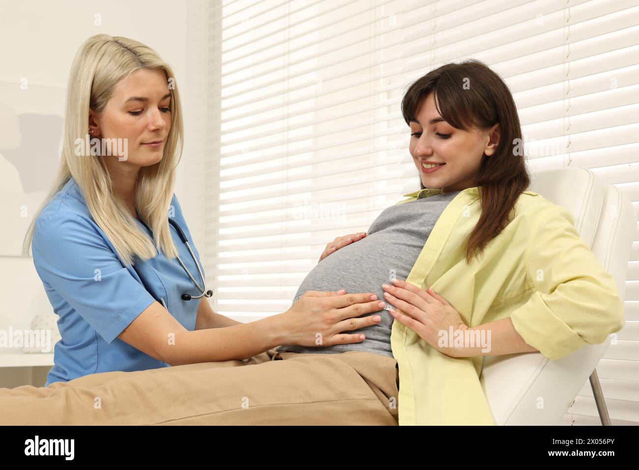 Pregnancy checkup. Doctor examining patient's tummy in clinic Stock ...