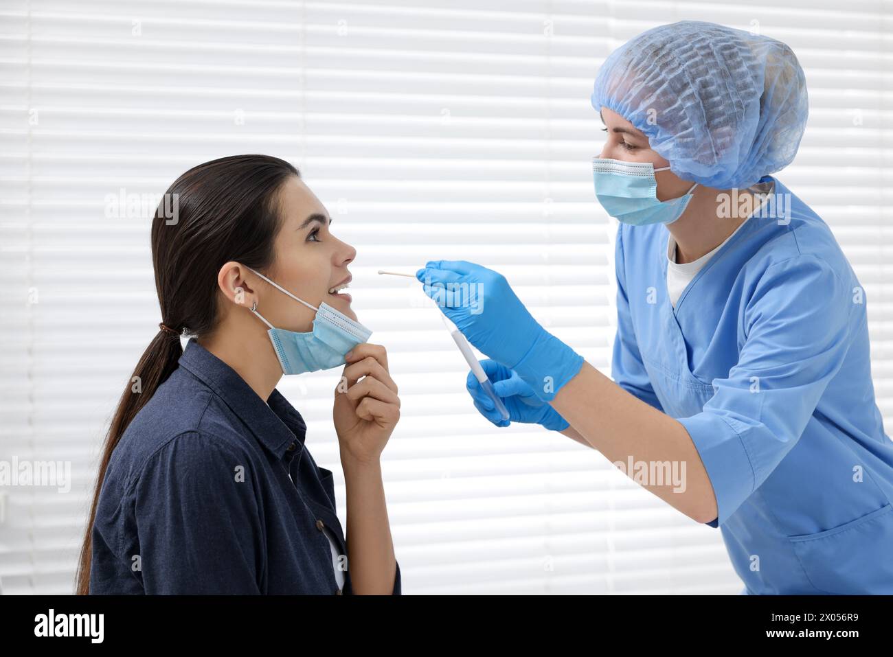 Laboratory testing. Doctor taking sample from patient's mouth with ...