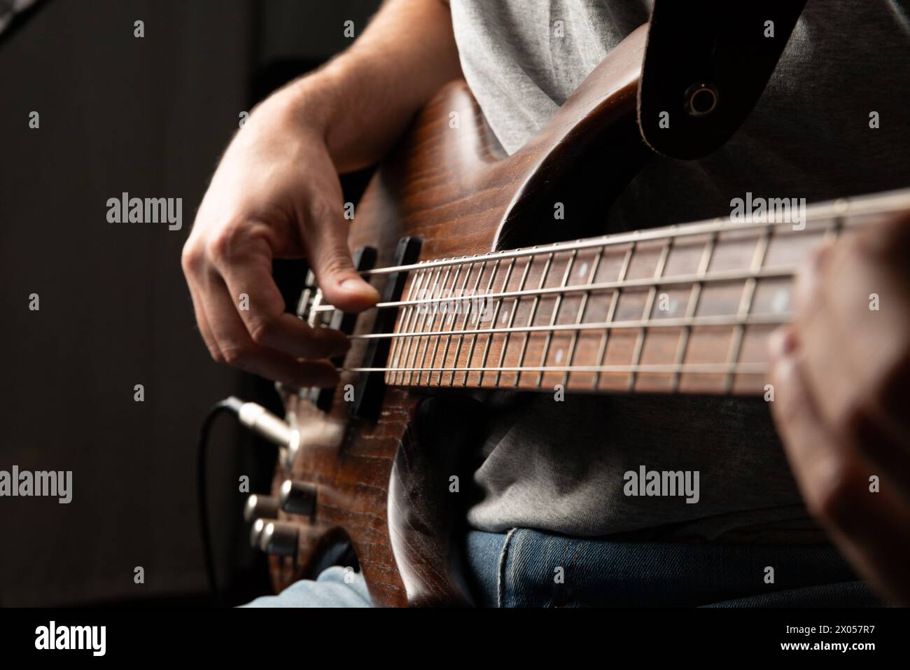 man playing musical piece on electric bass with fingers Stock Photo - Alamy