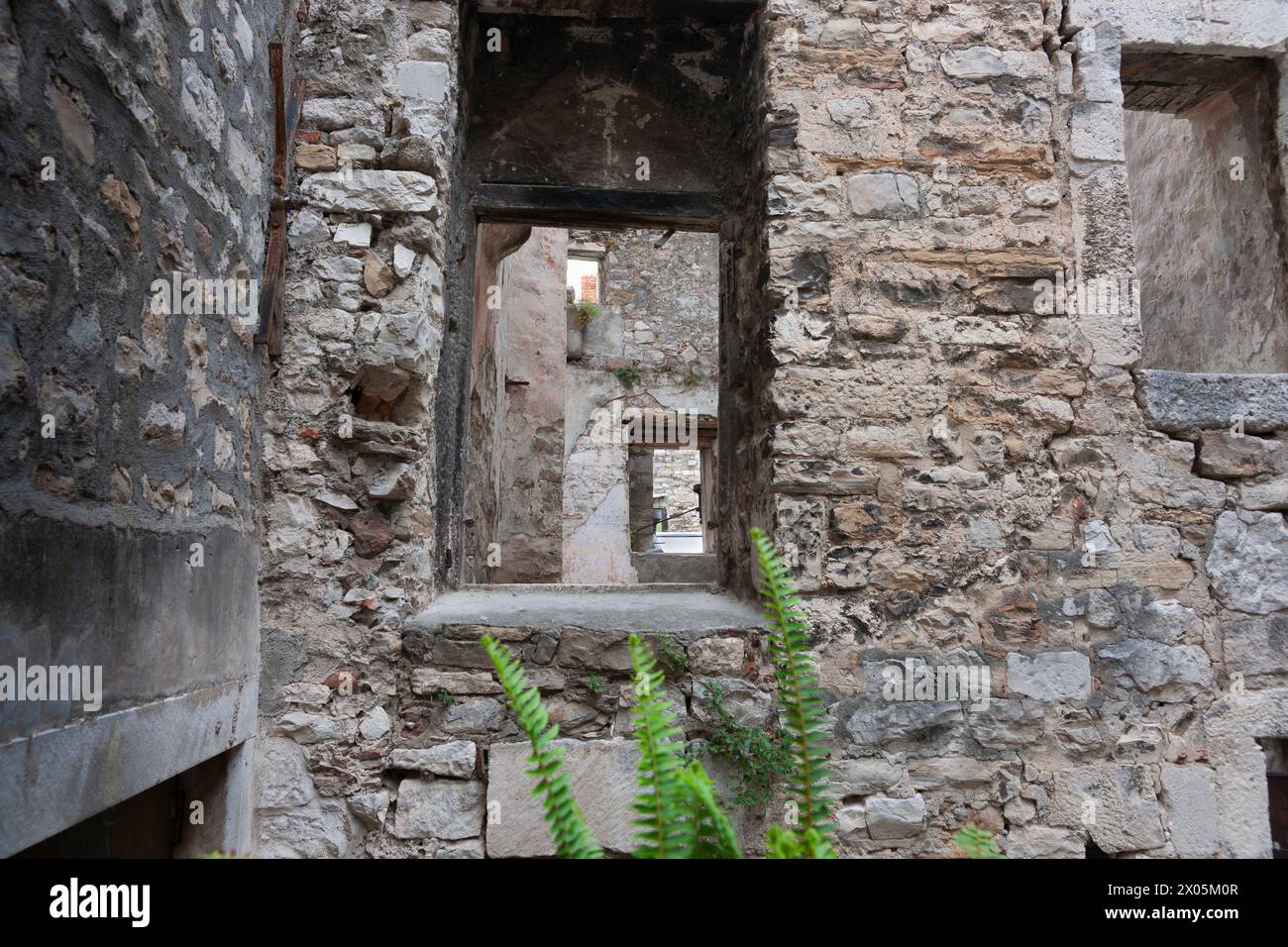 Old stone building walls with window openings through into distance and ...