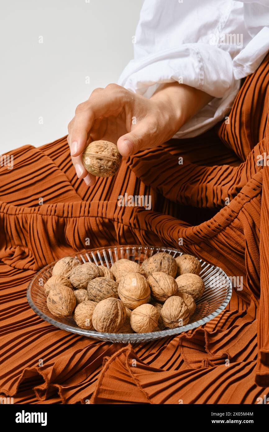 Unrecognizable woman placed a plate of walnuts on the hem of her skirt ...