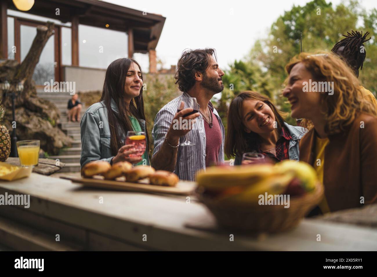 Group of friends at picnic sharing laughter and drinks at a rustic ...