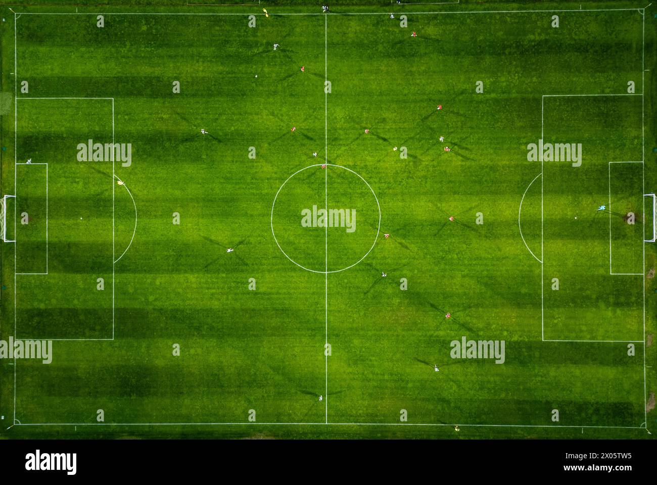 Aerial view of a soccer field in action, with players running, passing ...