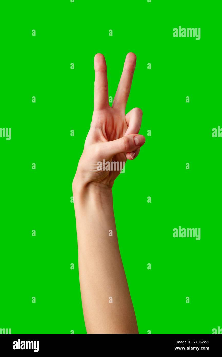 Hand Making Peace Sign Gesture Against Vibrant Green Background Stock ...