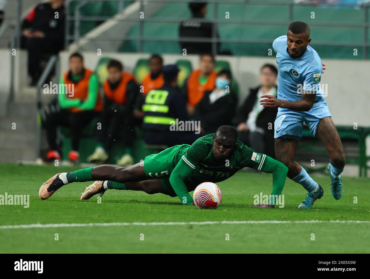 (240410) -- BEIJING, April 10, 2024 (Xinhua) -- Michael Ngadeu (L) of Beijing Guoan vies with ...