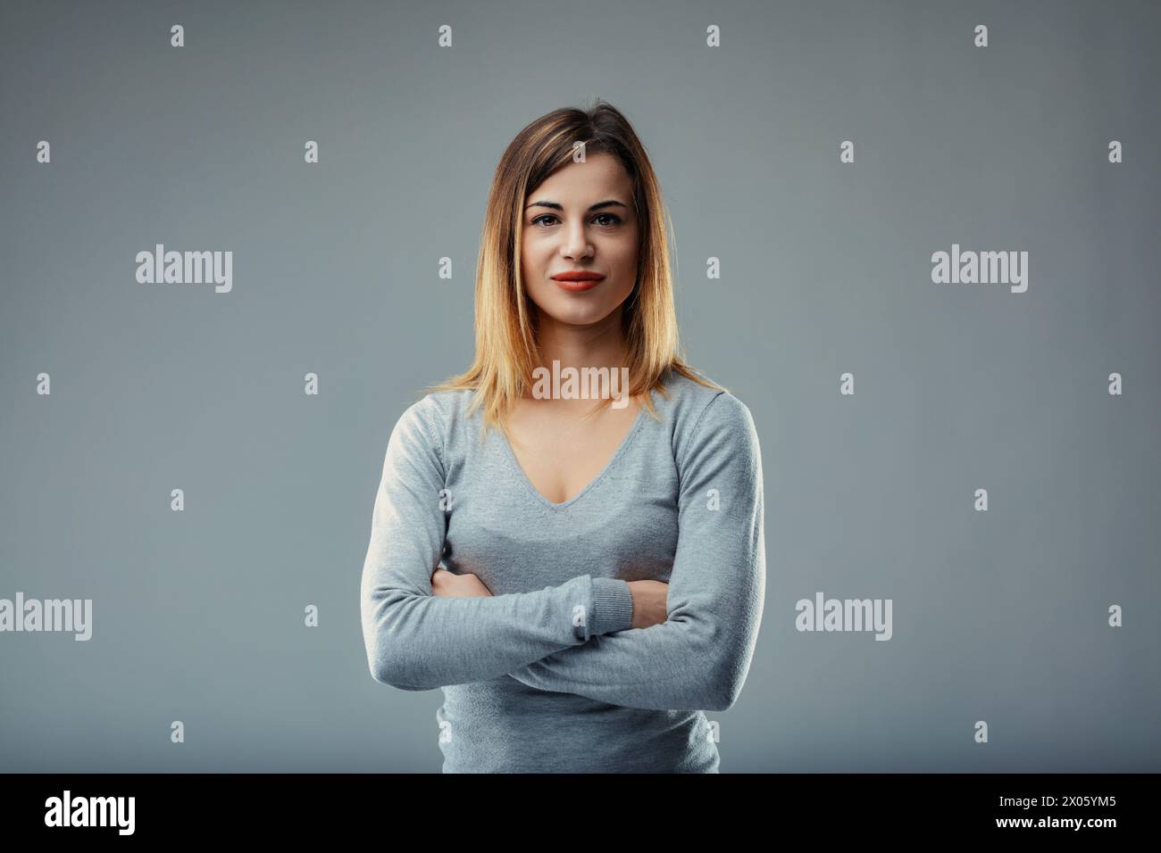 Confident woman with crossed arms stands ready to tackle any challenge ...