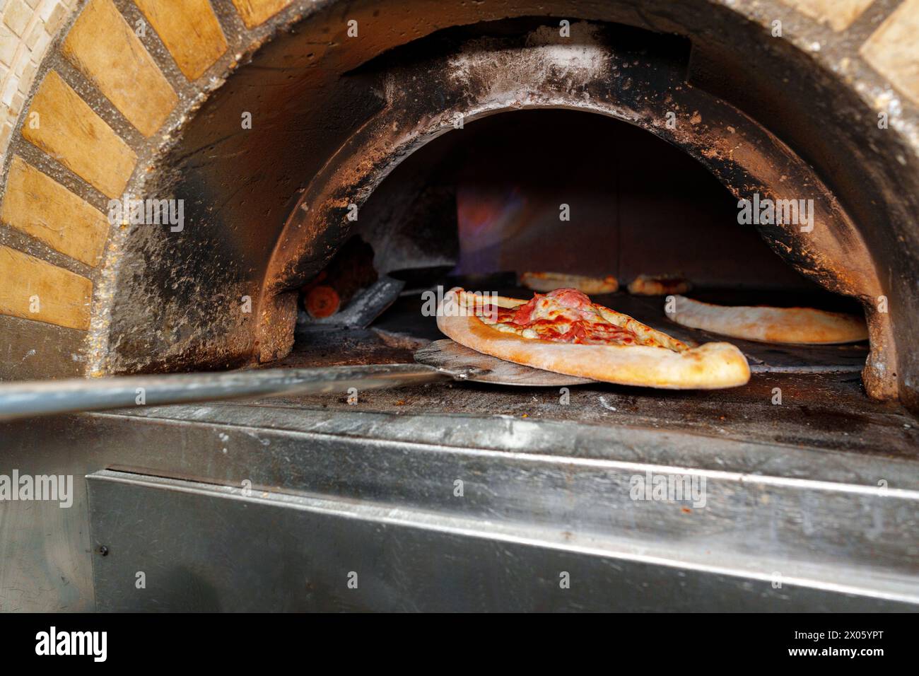 Pizza Cooking in Brick Oven Stock Photo - Alamy
