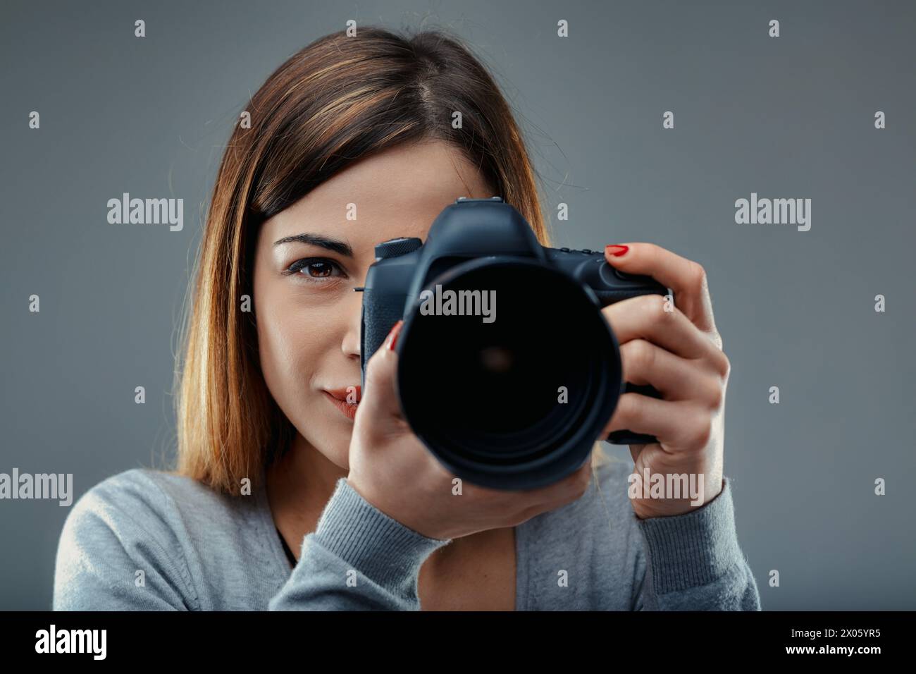 Camera-wielding woman displays a mix of concentration and artistry, eye ...