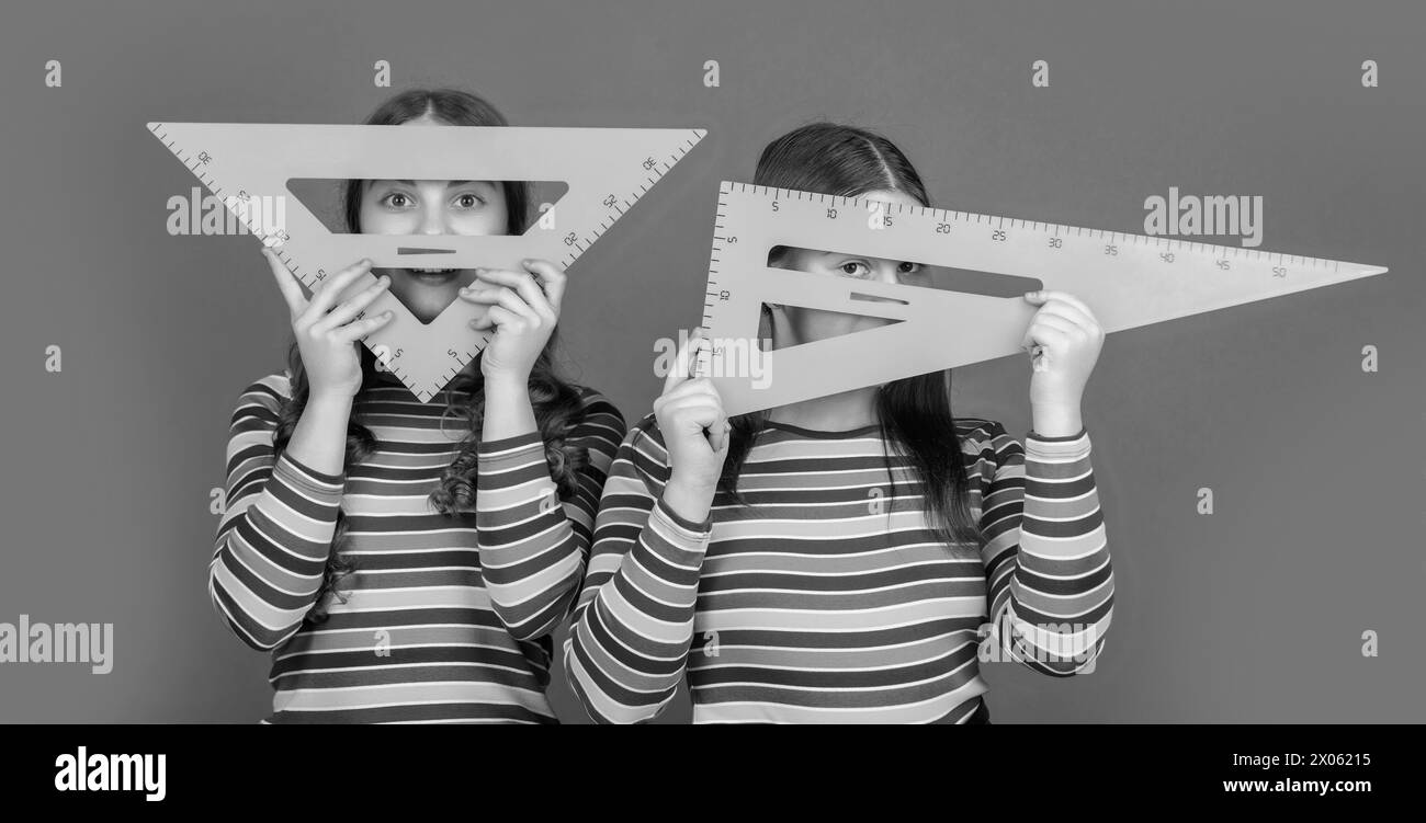 happy school students hold math tool of triangle Stock Photo - Alamy
