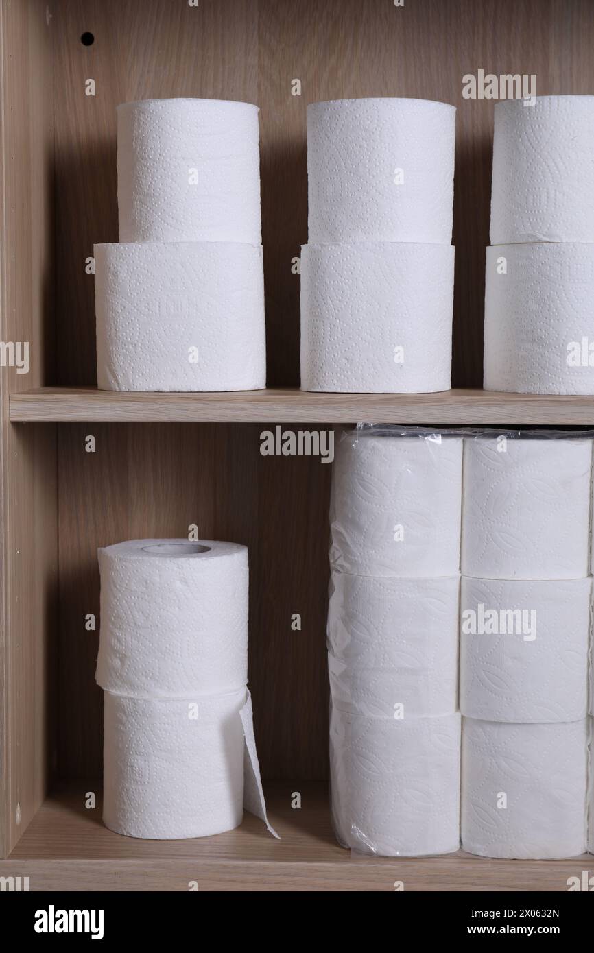 Stacked toilet paper rolls on wooden shelves Stock Photo - Alamy