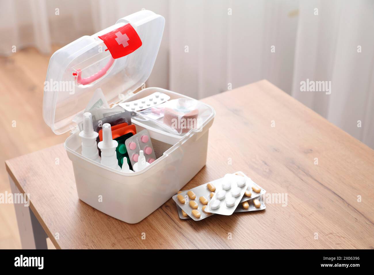 First aid kit and medicaments on wooden table indoors, space for text ...