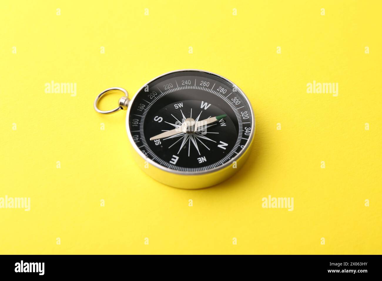 One compass on yellow background. Tourist equipment Stock Photo - Alamy