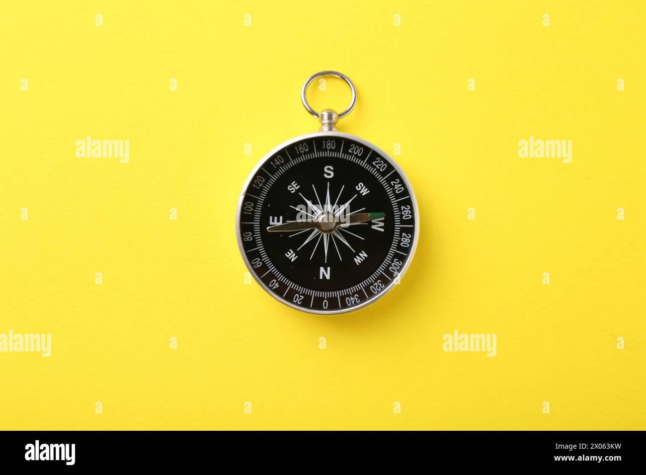One compass on yellow background, top view. Tourist equipment Stock ...