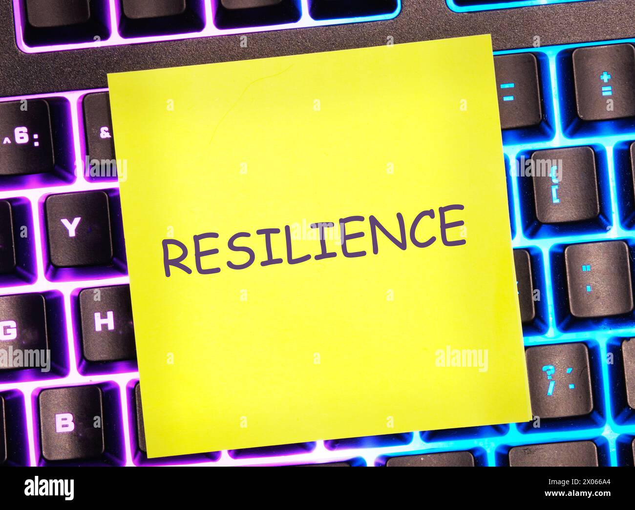 The written word RESILIENCE on a yellow sticker on a colored backlit ...