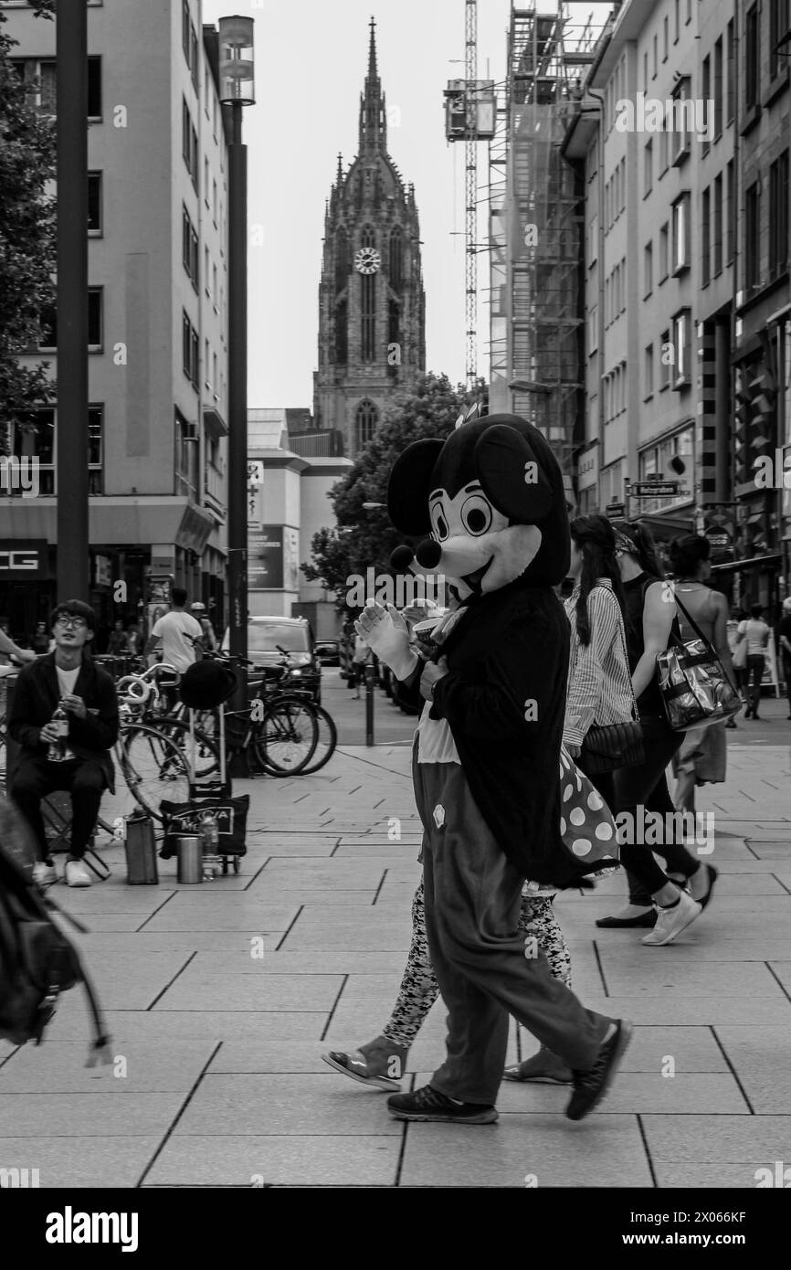 A person dressed as Mickey Mouse walking in the crowded streets of ...