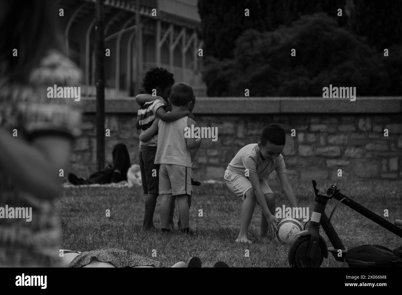 Two small children hugging while playing in Lake Como, black and white ...