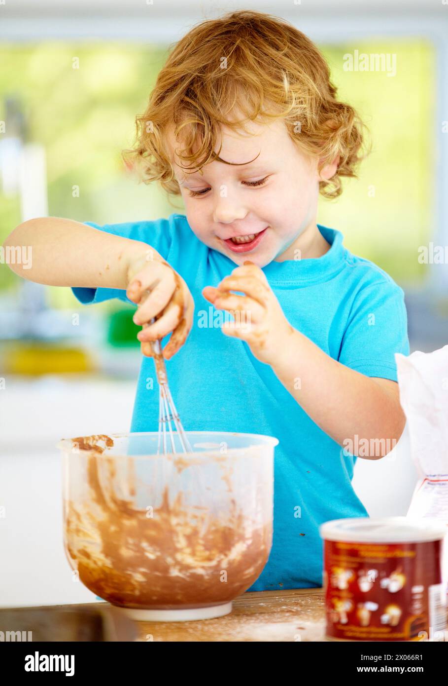 Baking, happy kid and learning in kitchen in home for development ...