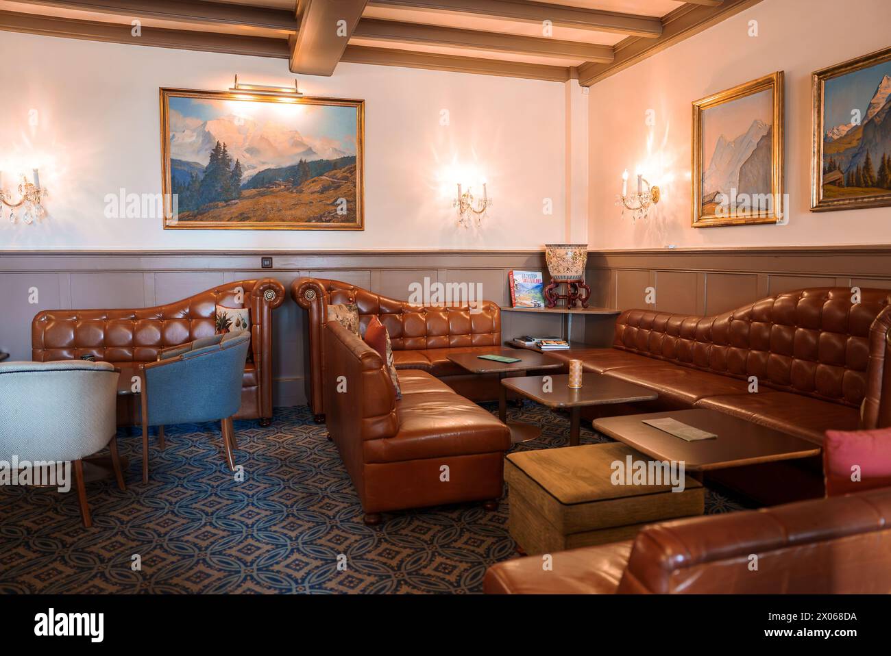 Classic lounge with leather sofas, blue chairs and vintage decor in ...