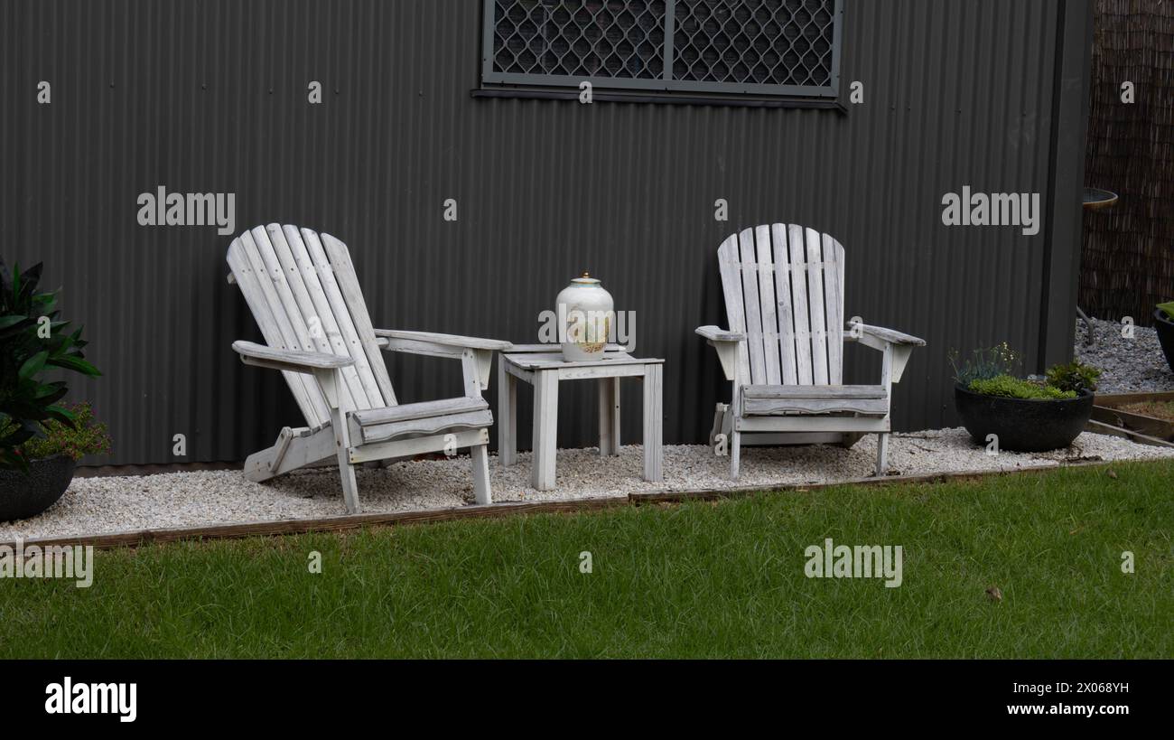 Two Adirondack chairs with table overlooking the backyard Stock Photo ...