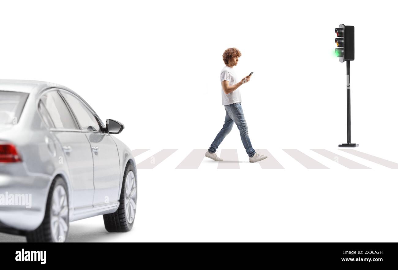 Car at a pedestrian and a young man holding a smartphone and crossing a ...